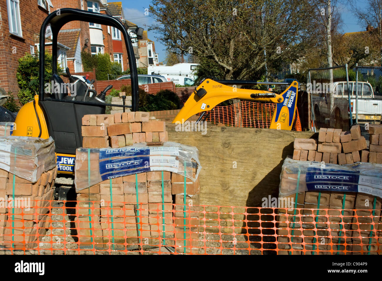 Digger with stacks of house bricks on the site of a newly built house ...