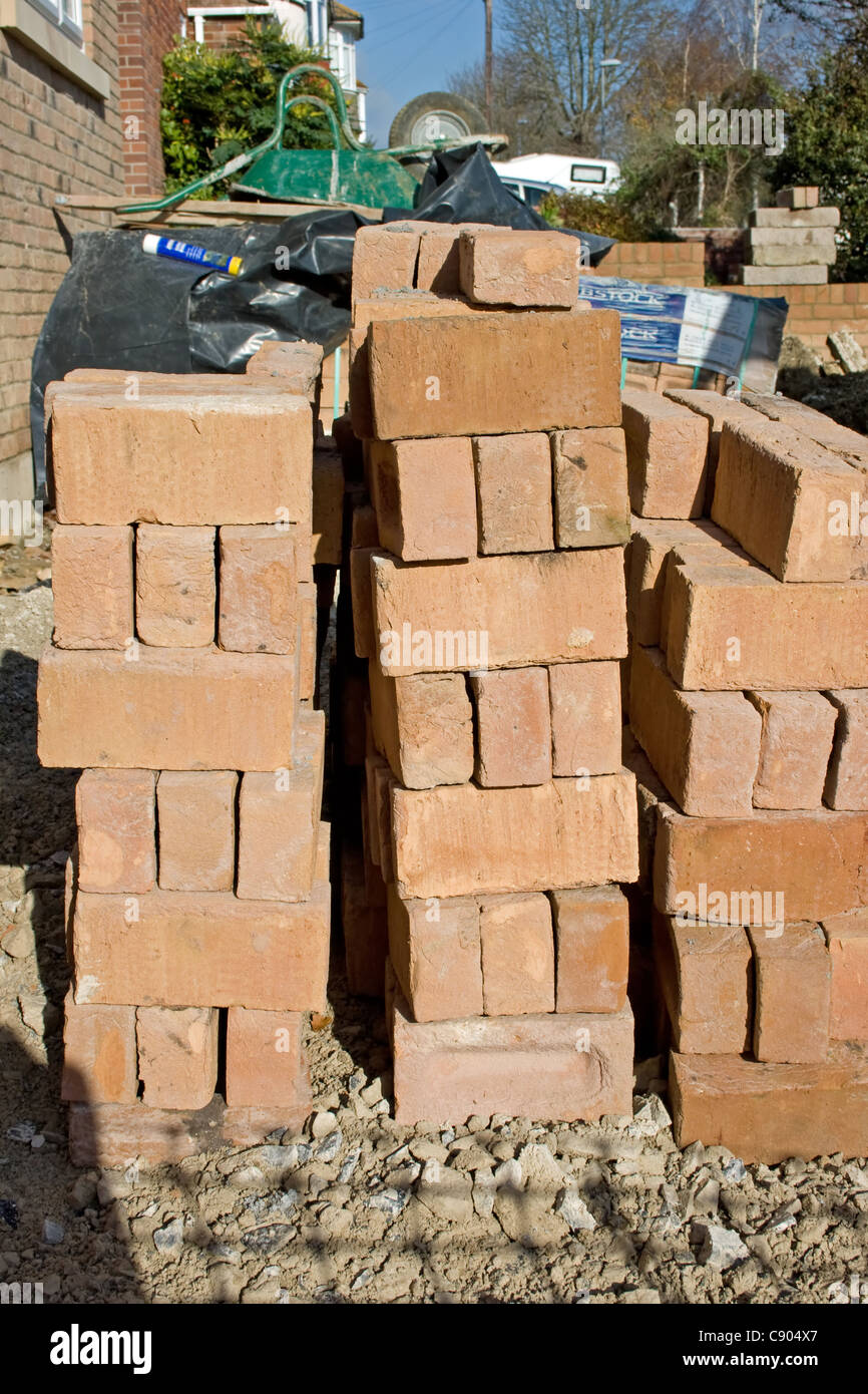 Piles or stacks of bricks to be used in the building of a garden wall ...