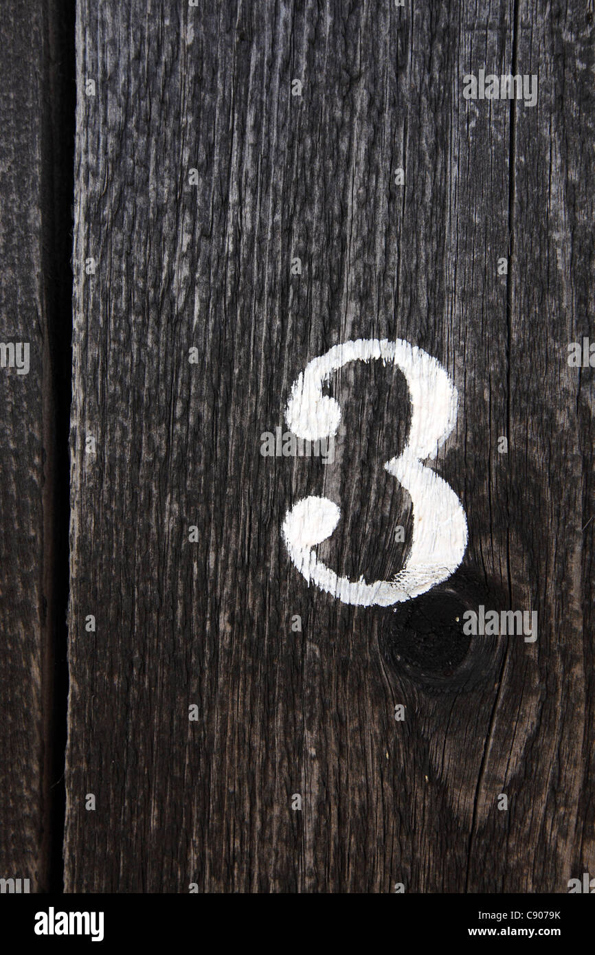 single digit number 3 three stenciled onto stained wooden door, Suffolk ...