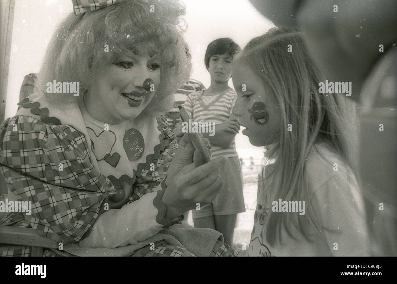 lulu the clown showing makeup to young girl in parking lot of Wal Mart ...