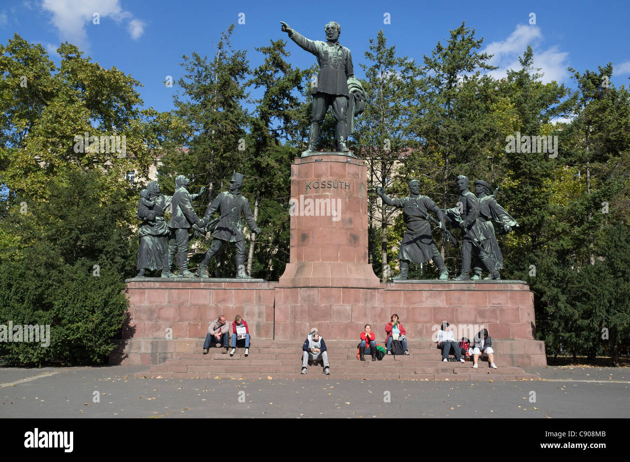 Tourists and locals rest under the Lajos Kossuth statue in Budapest ...