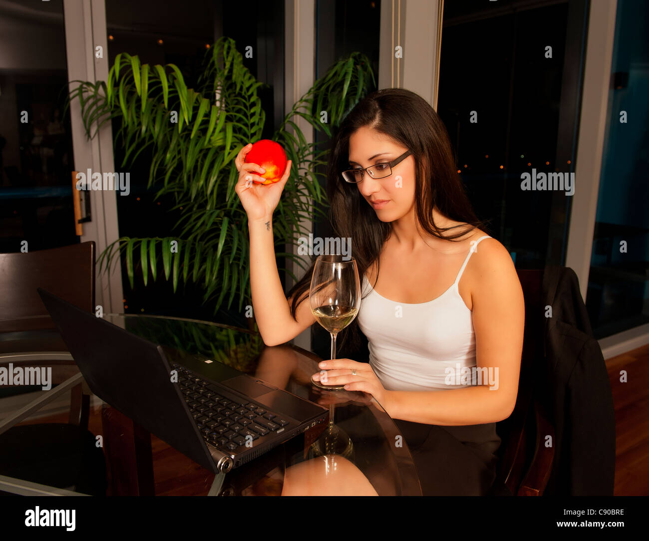 Hispanic woman 30s home sits in front of computer working late at night ...
