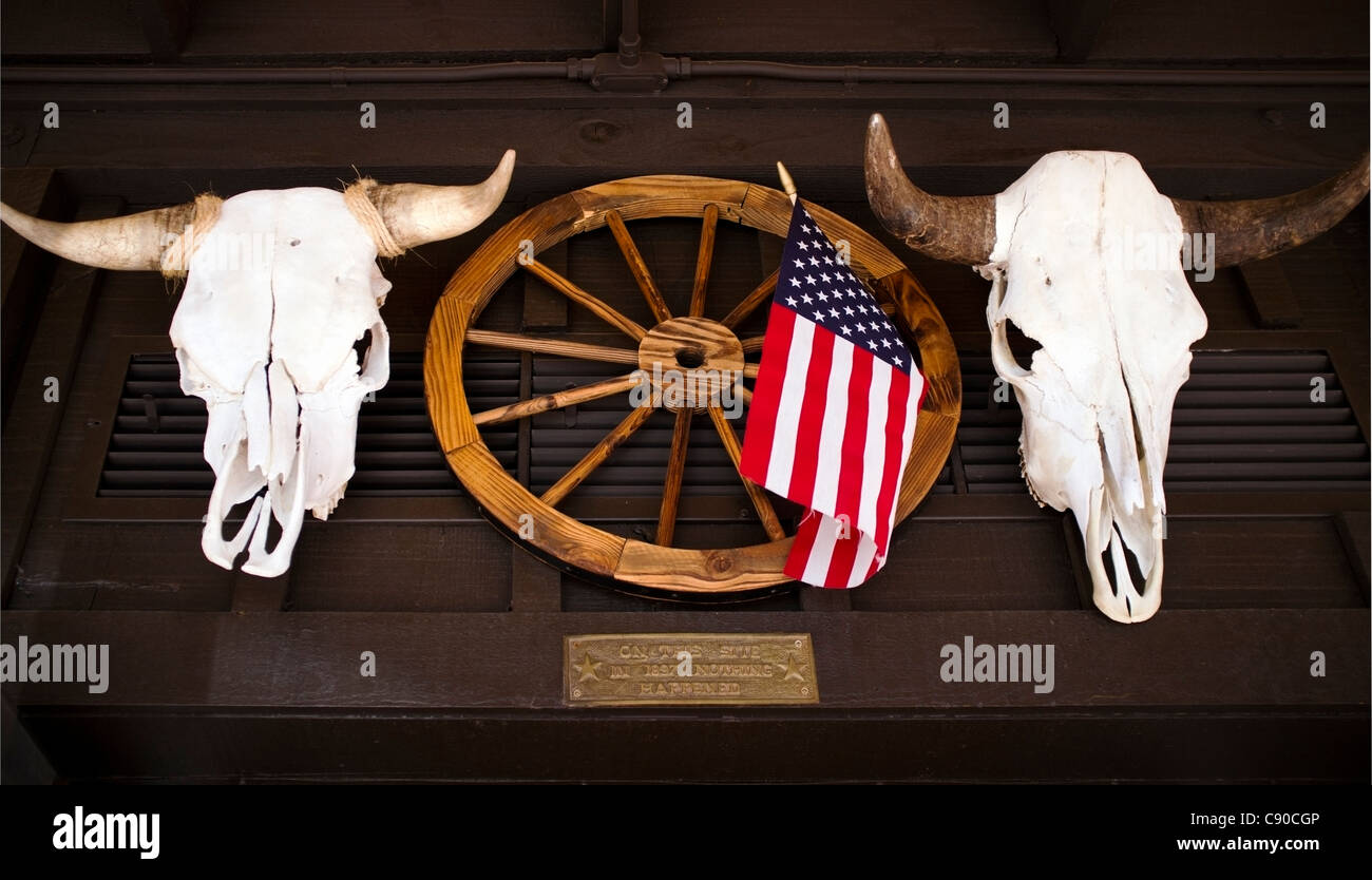 Two cow skulls, a wagon wheel and an American flag Stock Photo - Alamy