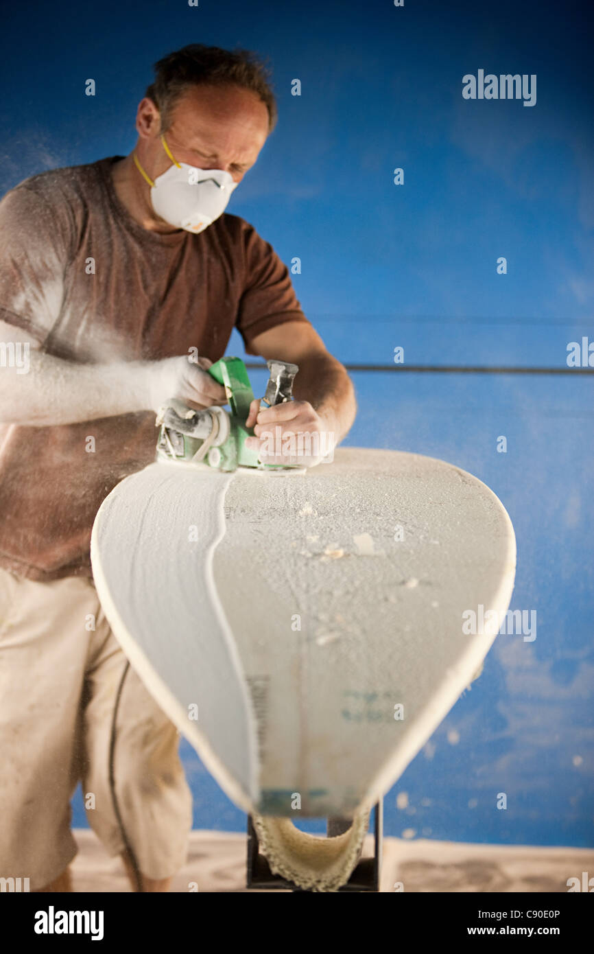 Man sanding surfboard Stock Photo - Alamy