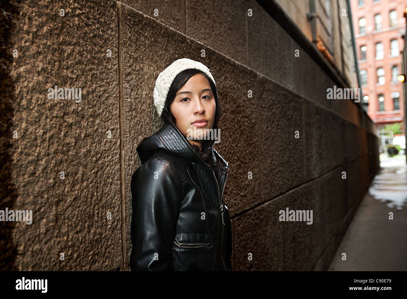 Young woman wearing knit hat by wall Stock Photo - Alamy