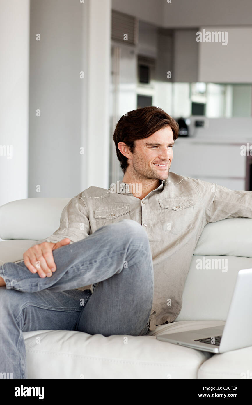 Man sitting on sofa, portrait Stock Photo - Alamy