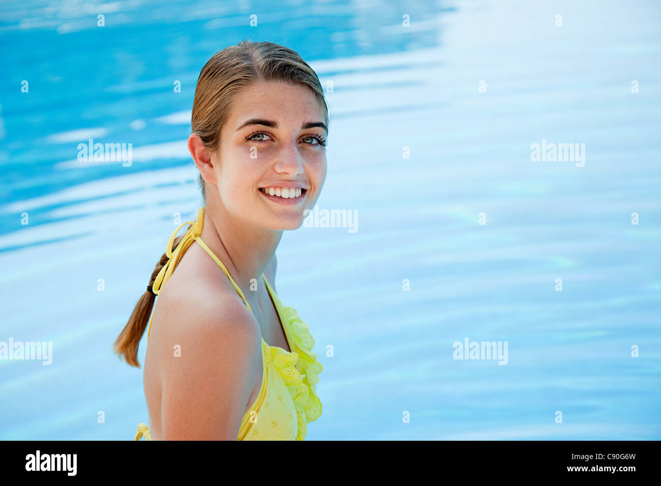 Young woman in yellow bikini by swimming pool, portrait Stock Photo - Alamy
