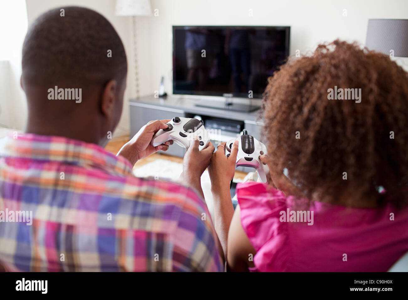 Couple playing video game at home Stock Photo - Alamy
