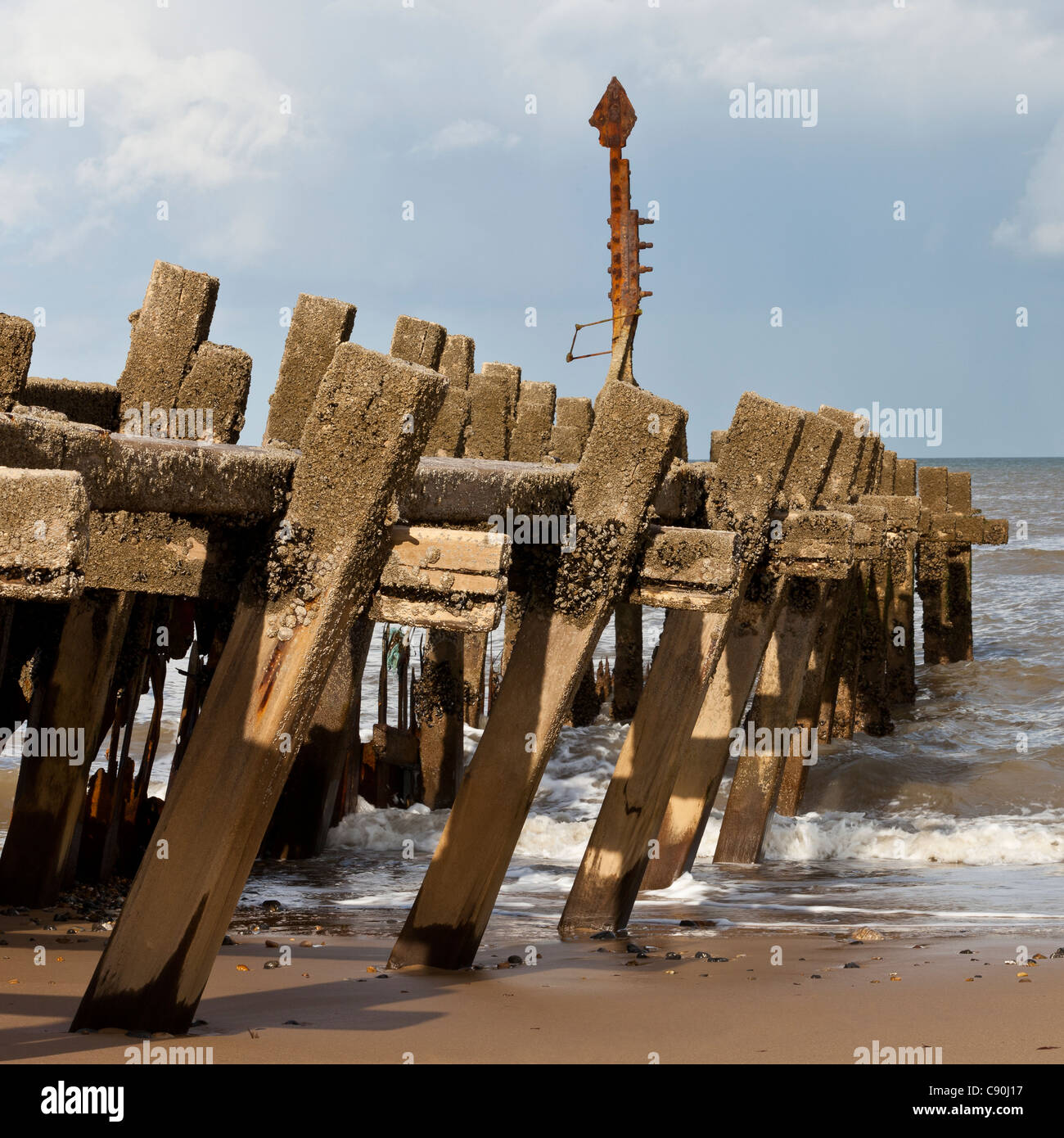 A twisted groyne on Walcott beach at low tide on the north Norfolk ...