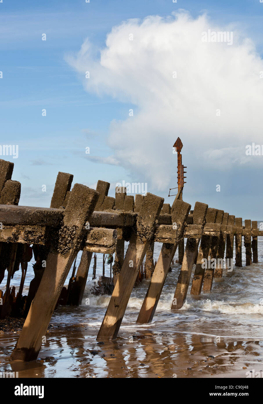 A twisted groyne on Walcott beach at low tide on the north Norfolk ...