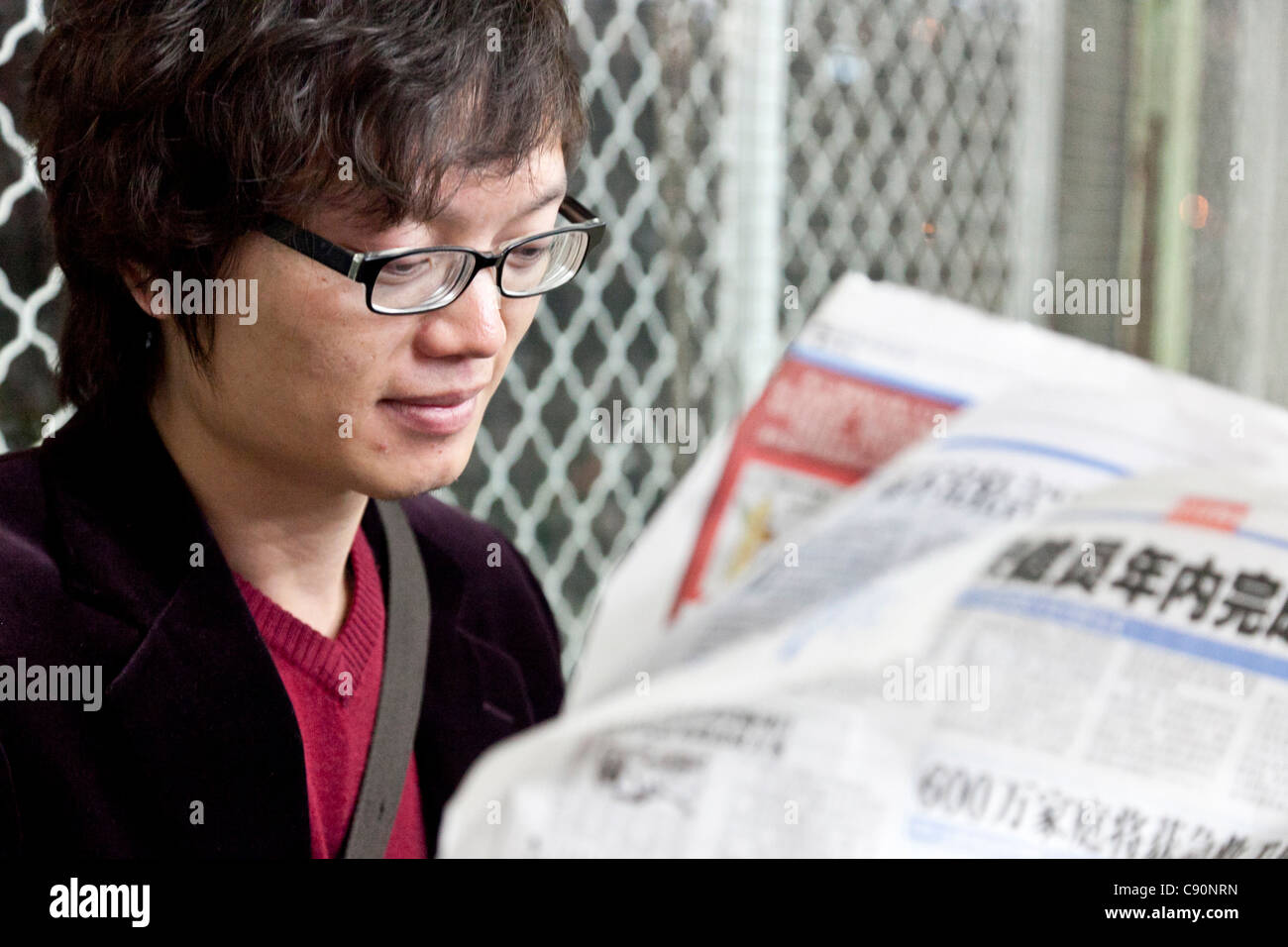 Young Chinese man reading the newspaper, Chinese characters, headlines ...