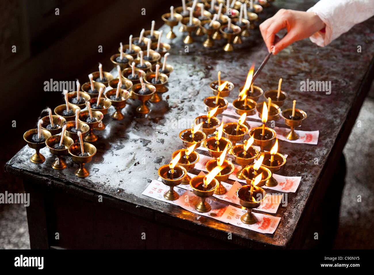 Oil lamps and butter lamps woman lighting a candle buddhist ritual ...