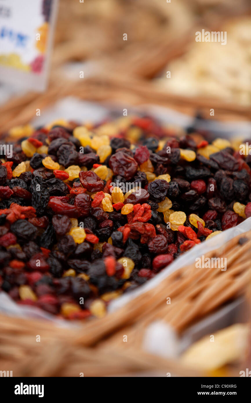 Mixed dried fruit on display on a market stall. Contained in a woven ...