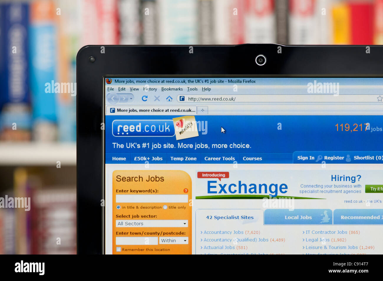 The Reed website shot against a bookcase background (Editorial use only ...