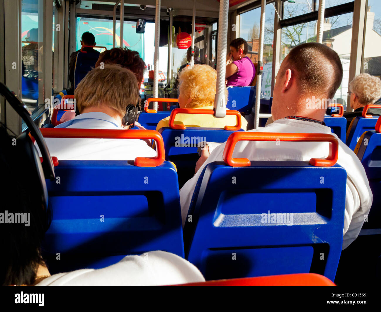 Interior showing passengers on a crowded bus on a sunny day in England ...