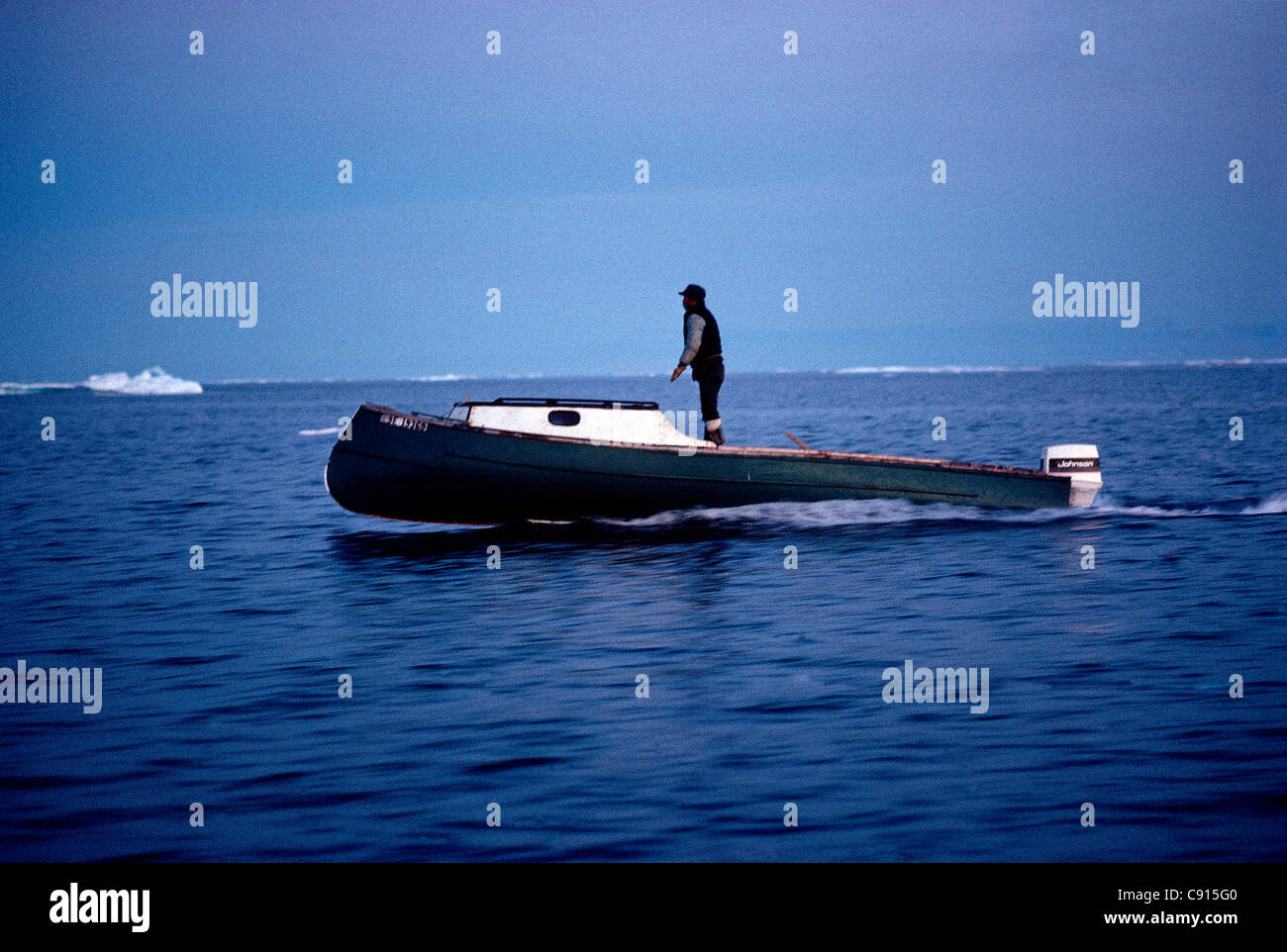 Native Inuit hunter traveling at dusk in his Inuit Freighter Canoe ...