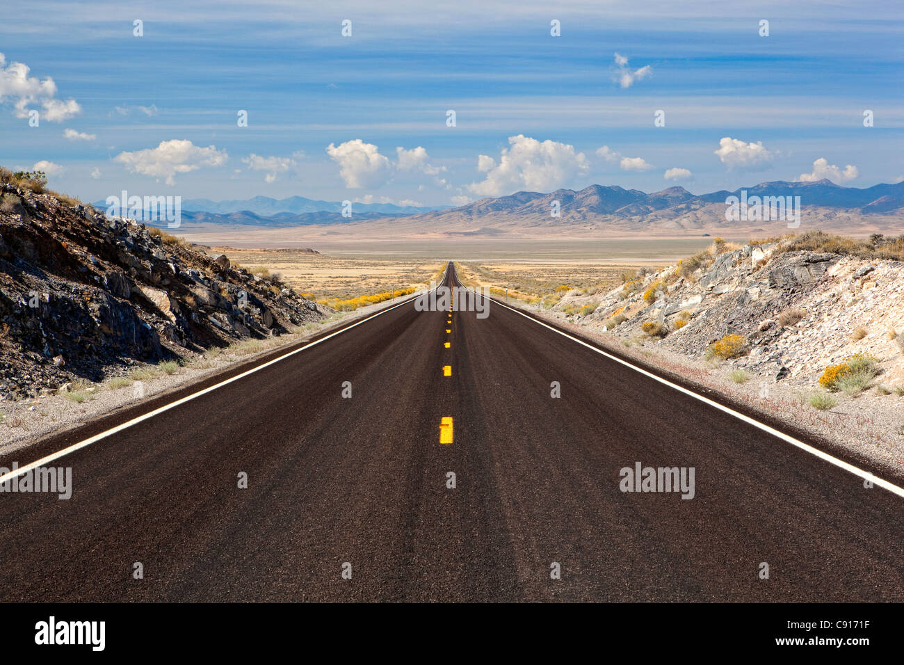 A long straight road going thought the desert to some mountains in ...