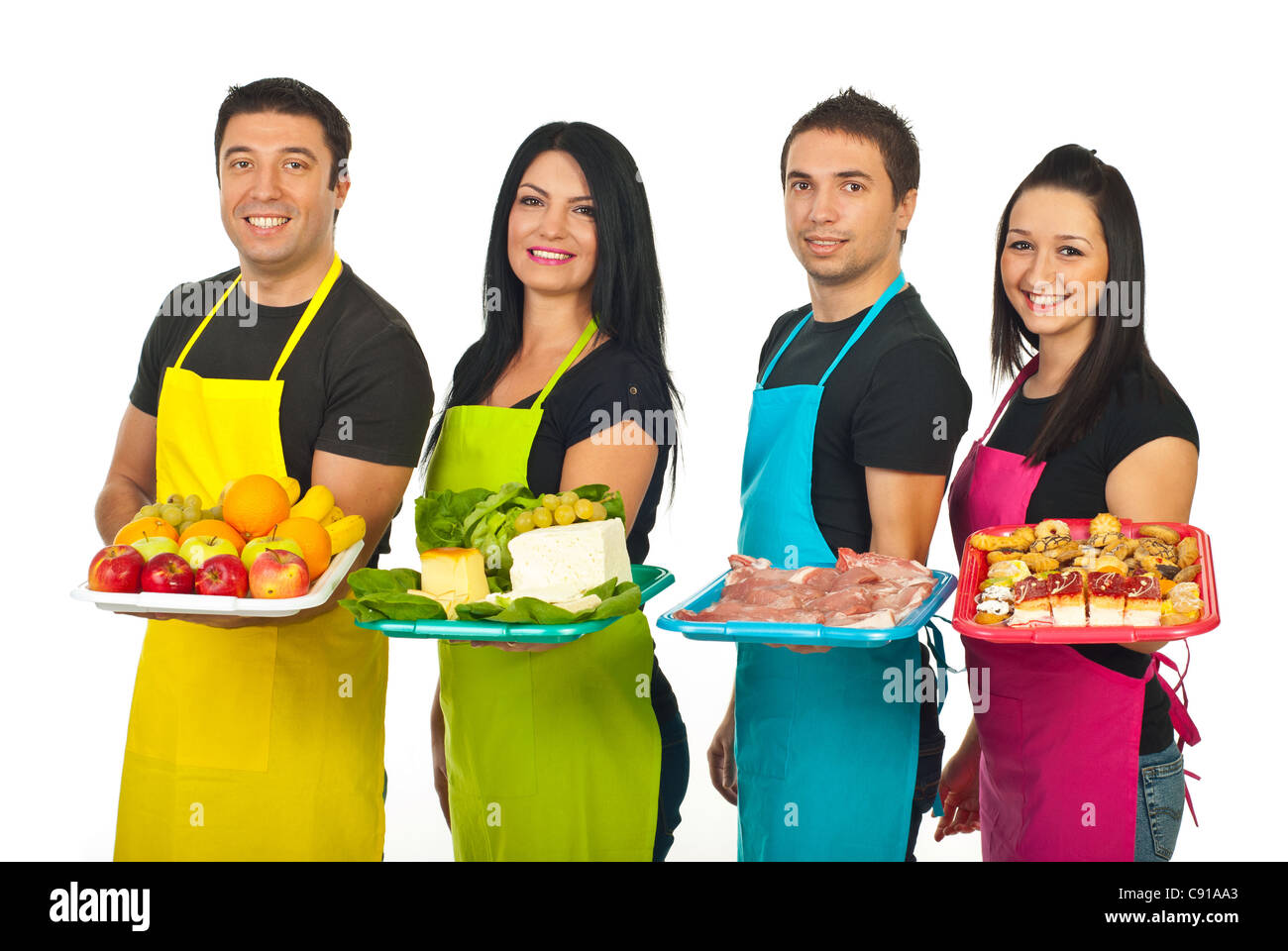 Four market workers standing in a line and holding their fresh products ...
