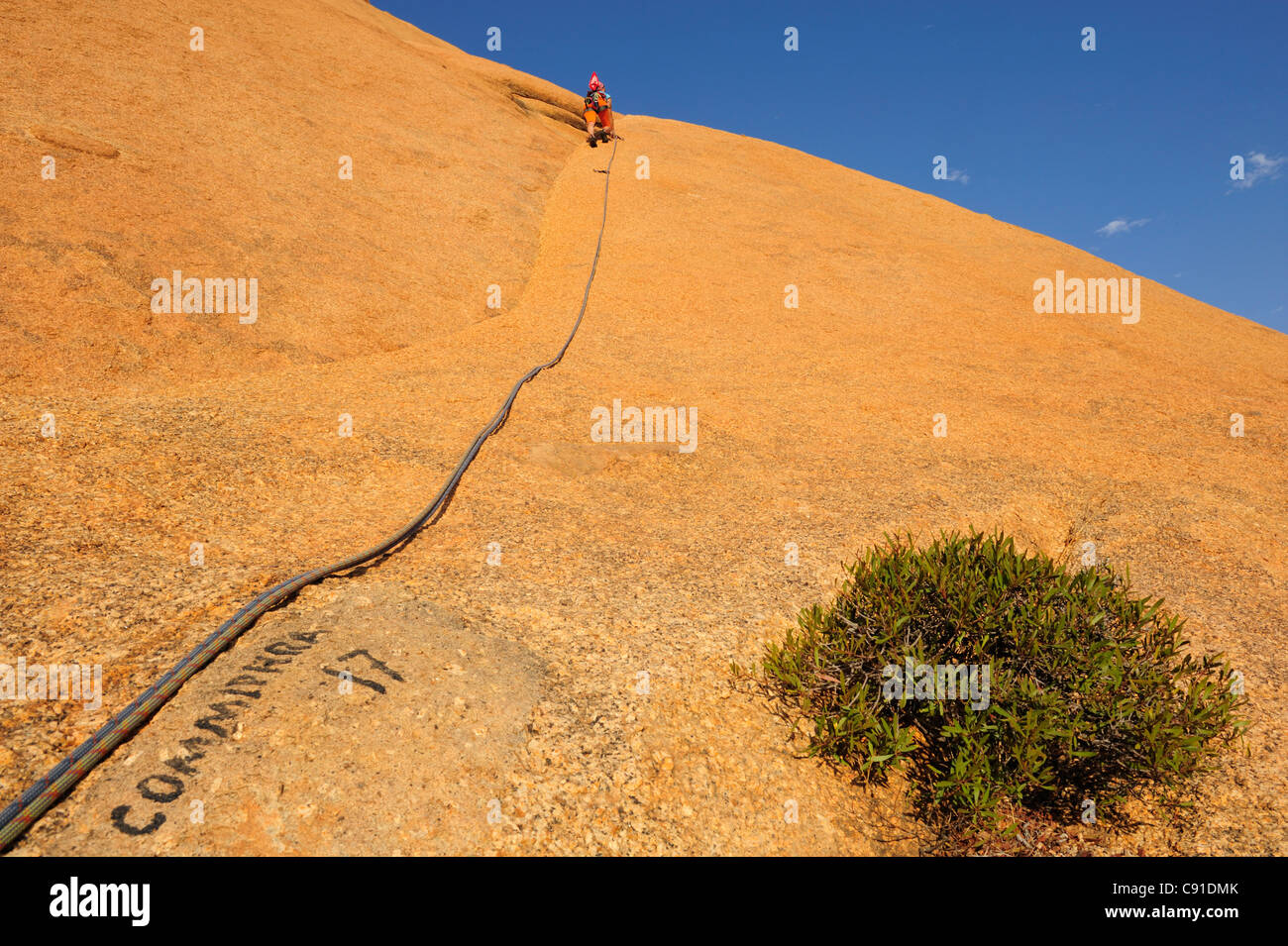 Woman climbing at red rock face, Great Spitzkoppe, Namibia Stock Photo ...