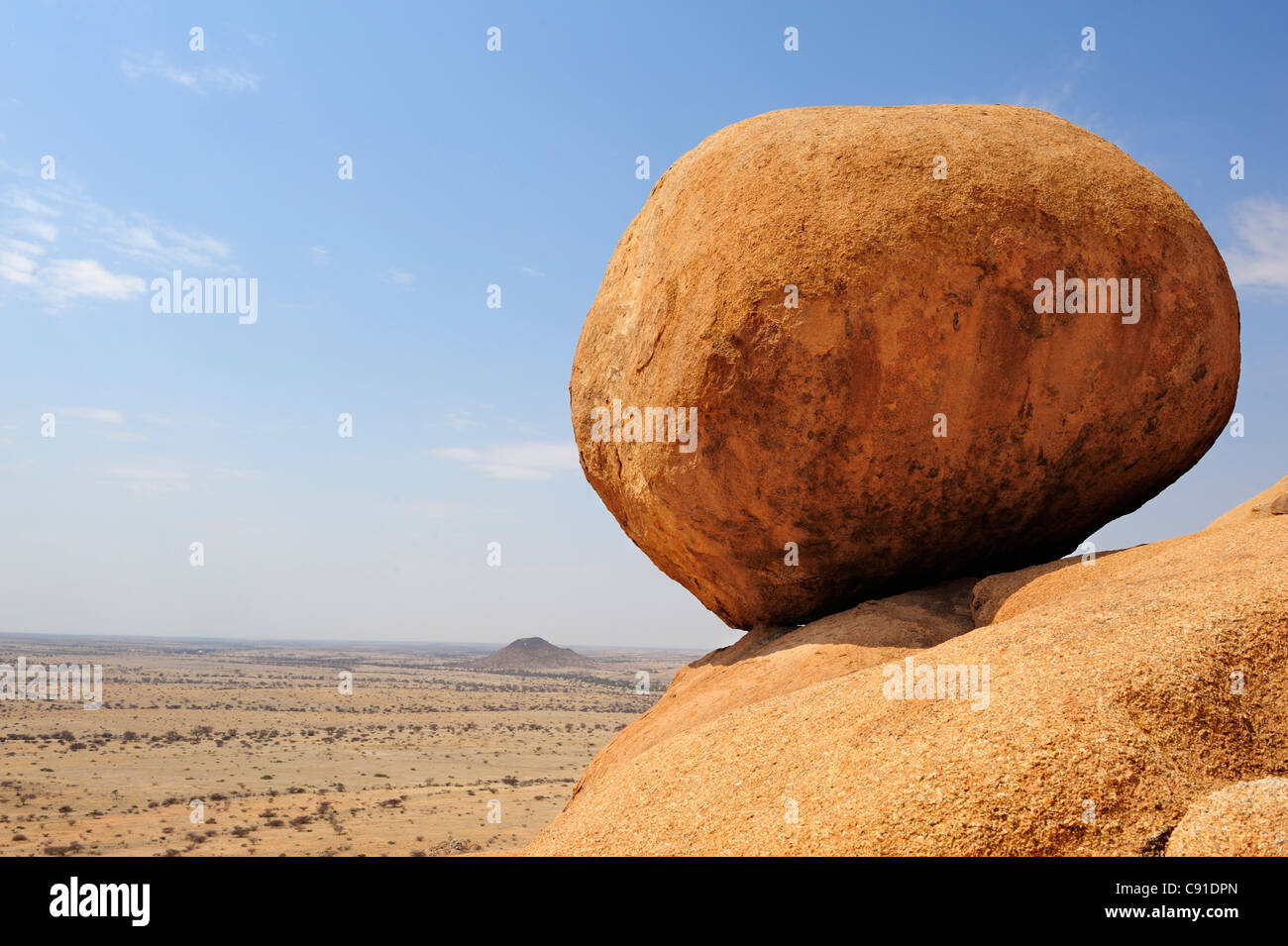 Red balancing granite rock on slab in front of savannah, Great ...