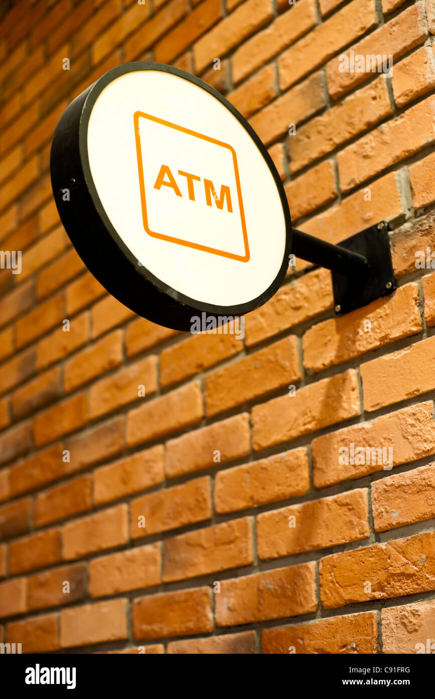 Circle shape ATM sign on brick wall Stock Photo - Alamy