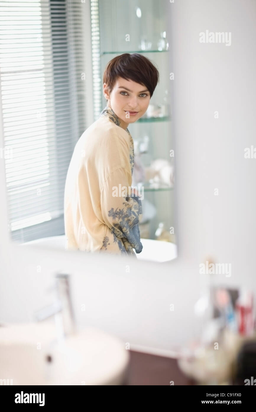 Woman in robe sitting in bathroom Stock Photo - Alamy