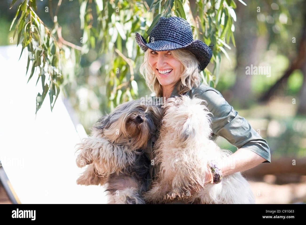 Woman carrying dogs outdoors Stock Photo - Alamy