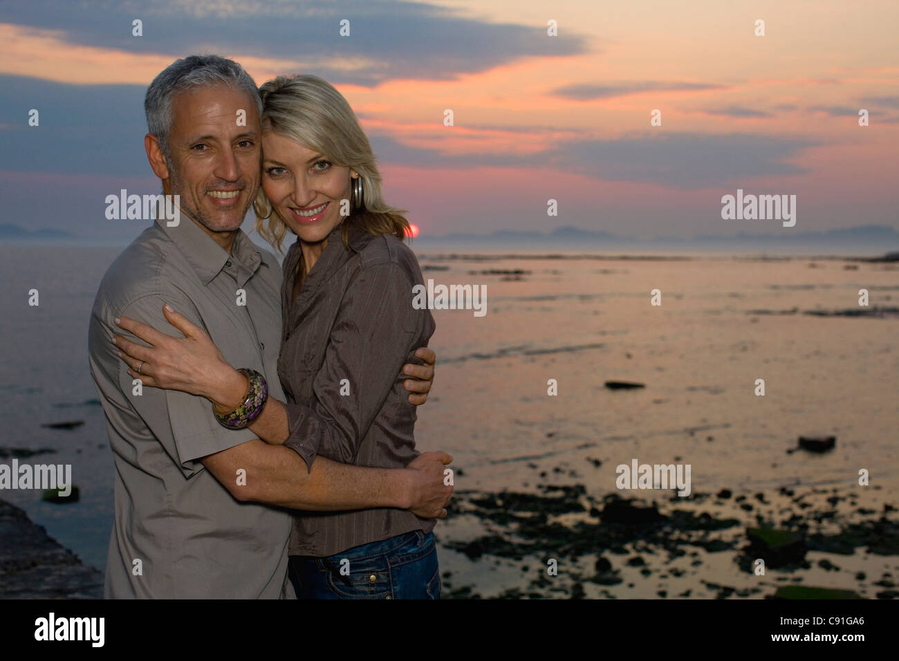 Couple hugging at sunset Stock Photo - Alamy