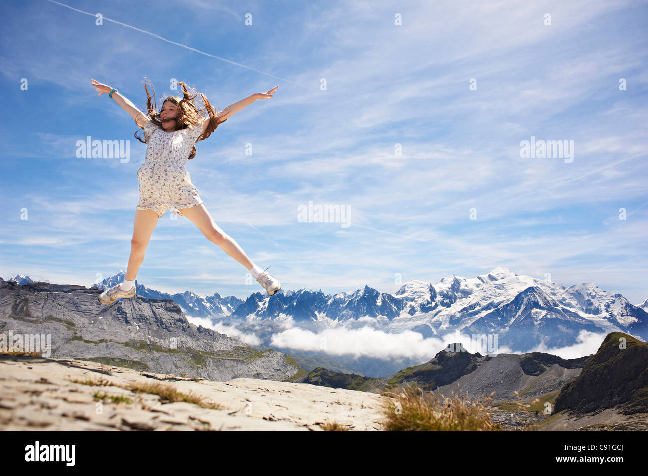 Girl jumping in rocky landscape Stock Photo - Alamy