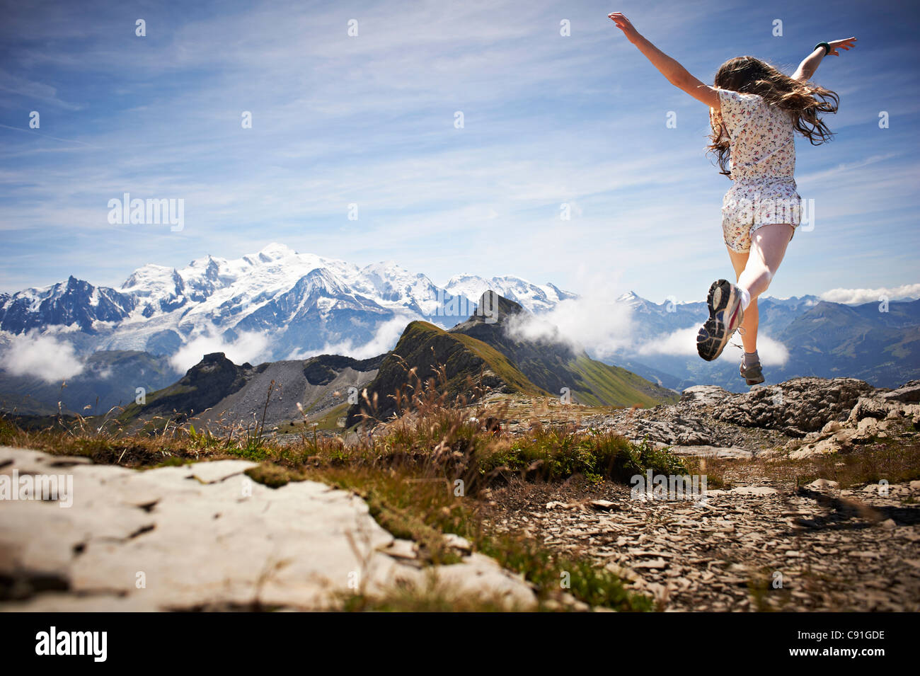 Girl jumping in rocky landscape Stock Photo - Alamy