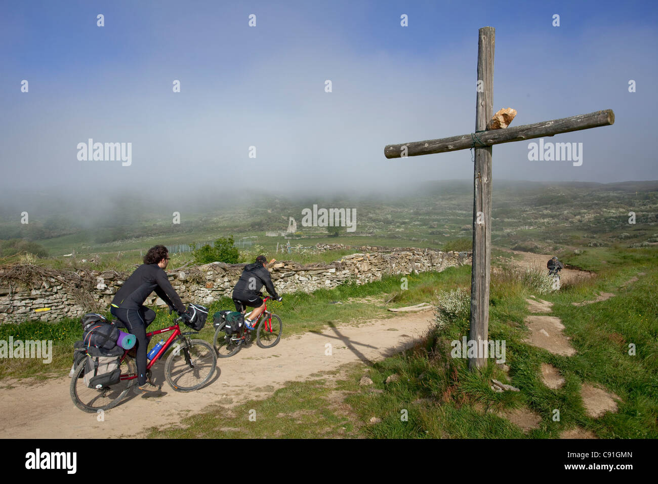 Pilgrims on bicycles at a wayside cross Province of Leon Old Castile ...