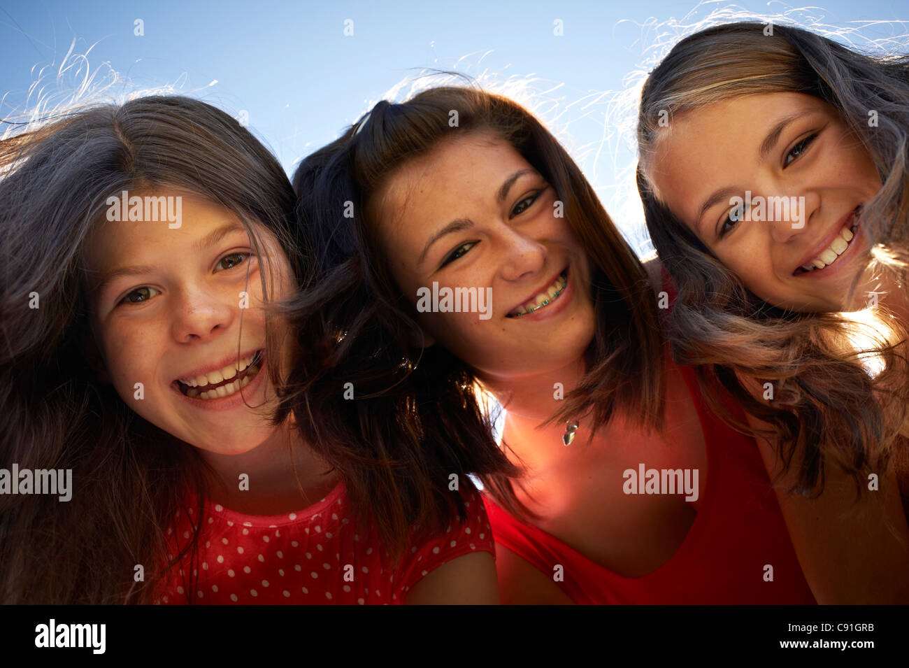 Girls smiling against blue sky Stock Photo - Alamy