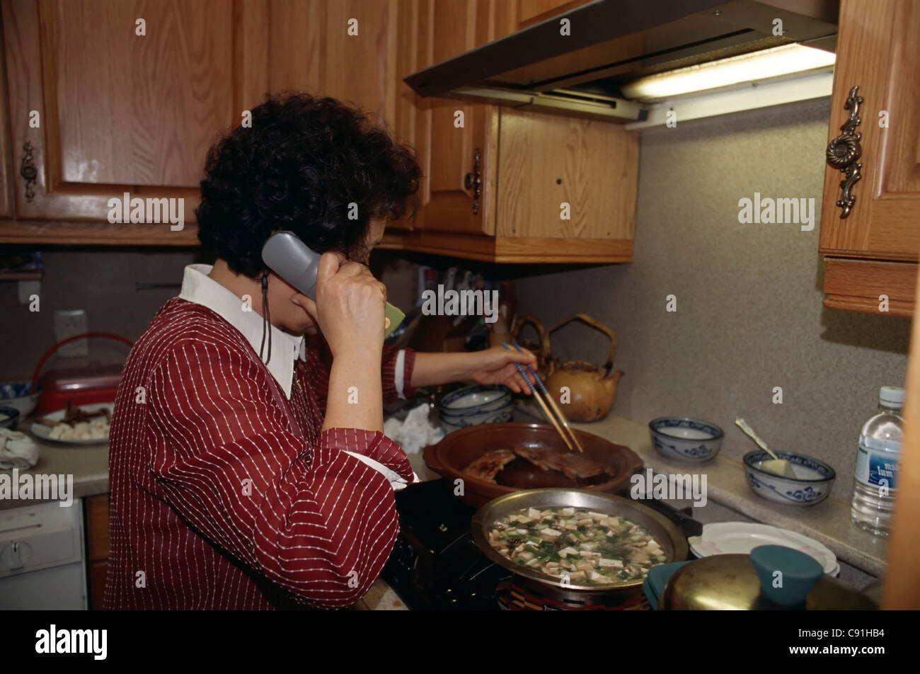 Woman cooking and talking on the phone, Daegu, South Korea Stock Photo ...