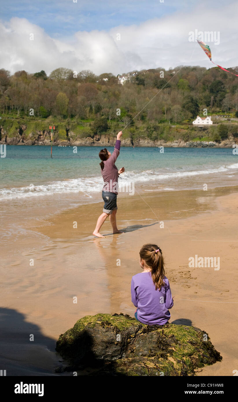 Girl sitting on a rock at Salcombe's Mill Bay Beach, Devon, England, UK ...
