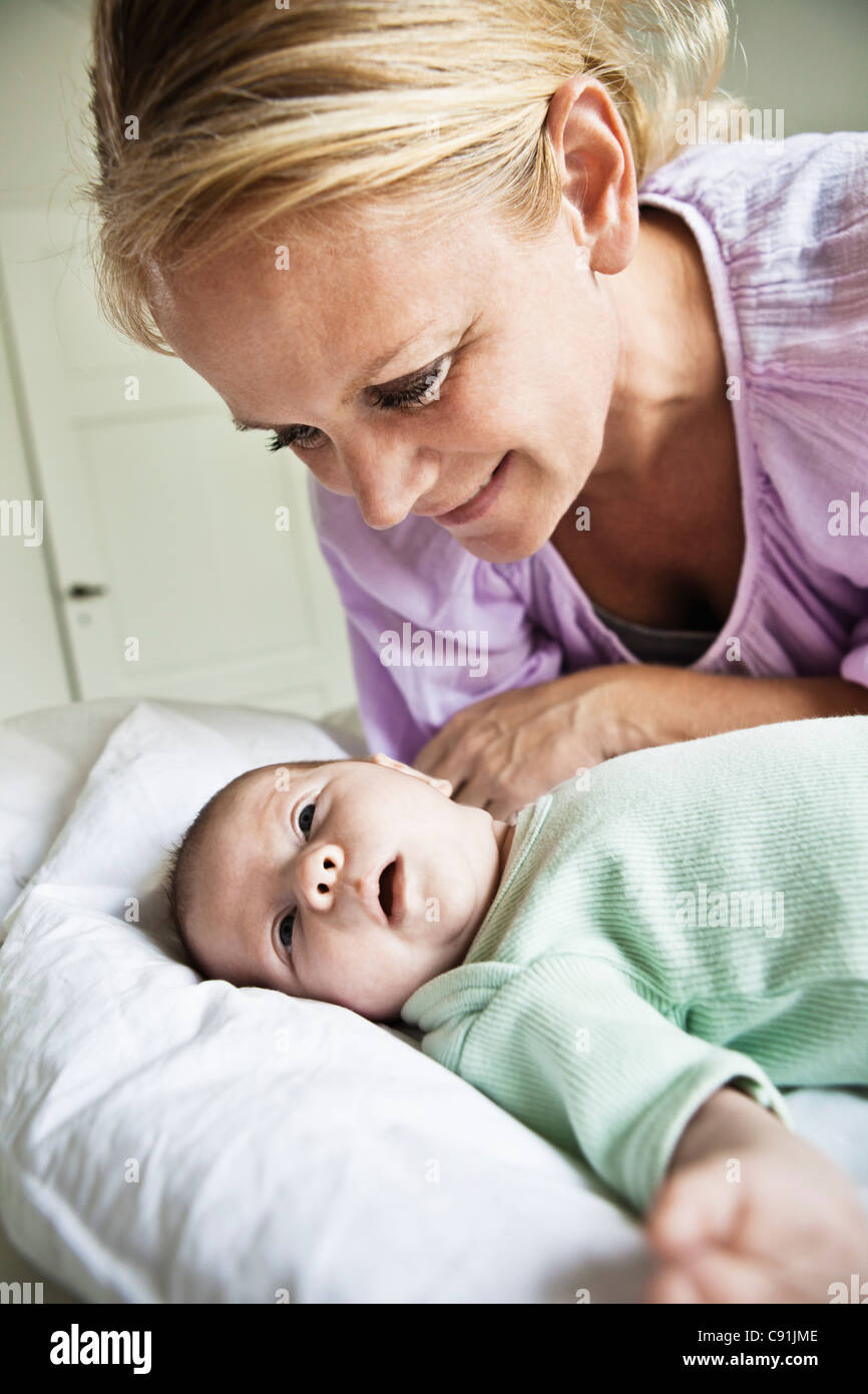 Mother admiring infant on bed Stock Photo - Alamy
