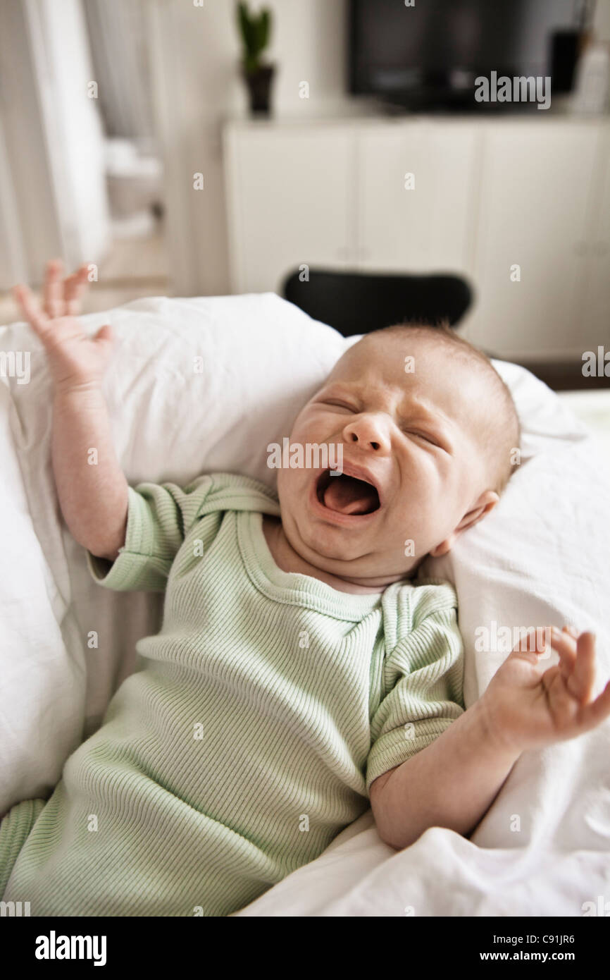 Infant crying in bed Stock Photo - Alamy