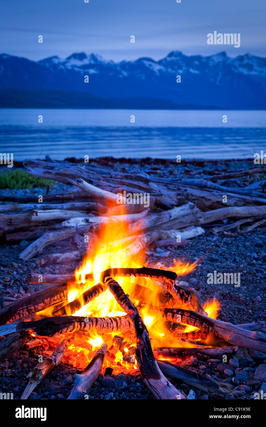 Campfire at dusk on a remote coastal beach in Goose Cove, Muir Inlet ...