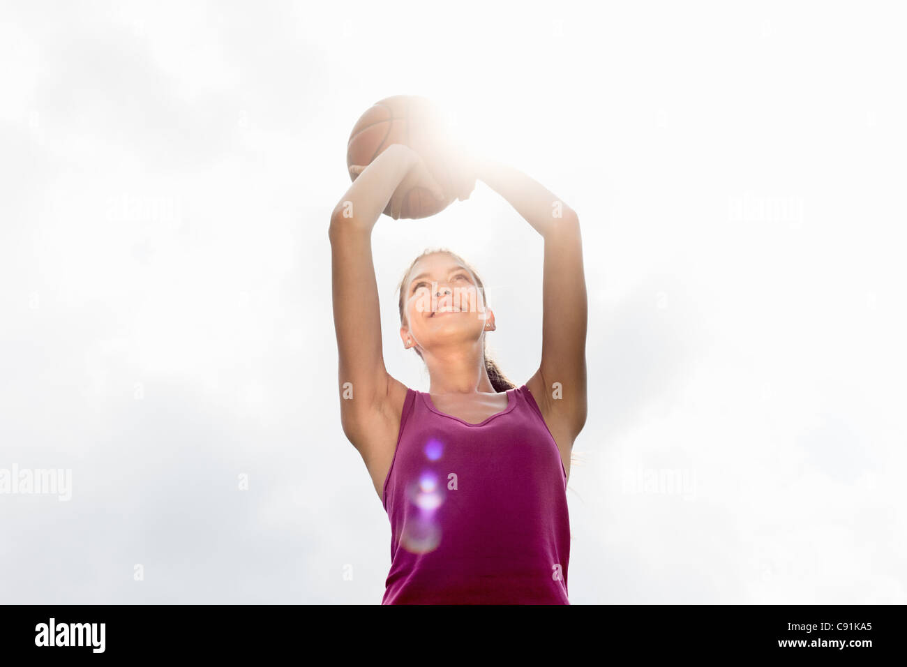 Woman shooting basketball Stock Photo - Alamy