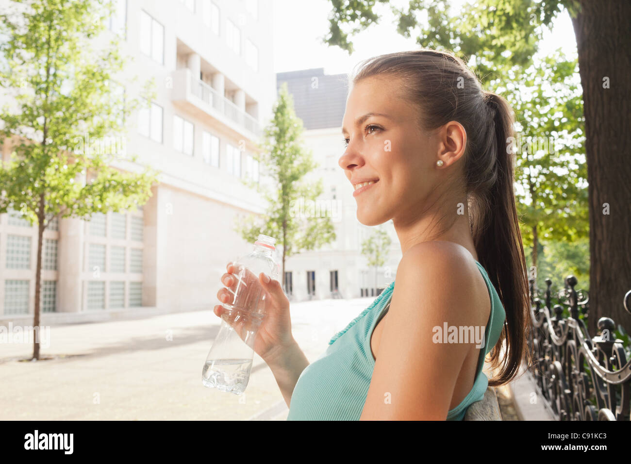 Woman drinking water on park bench Stock Photo - Alamy