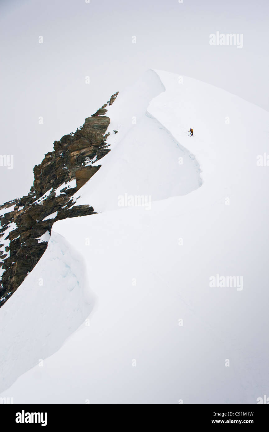 Skier ascends the north ridge of Mount Chamberlin in the Brooks Range ...
