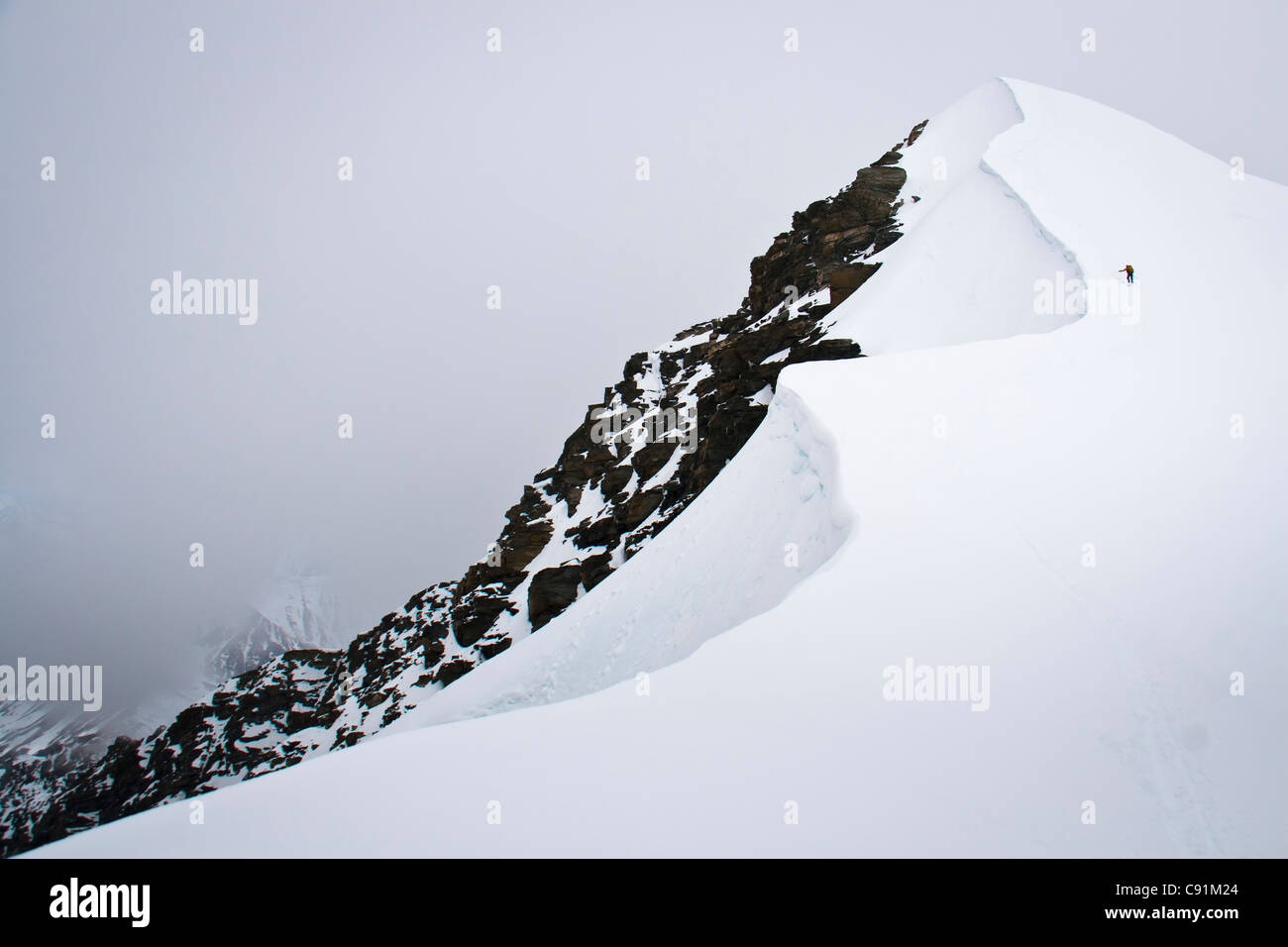 Skier ascends the north ridge of Mount Chamberlin in the Brooks Range ...
