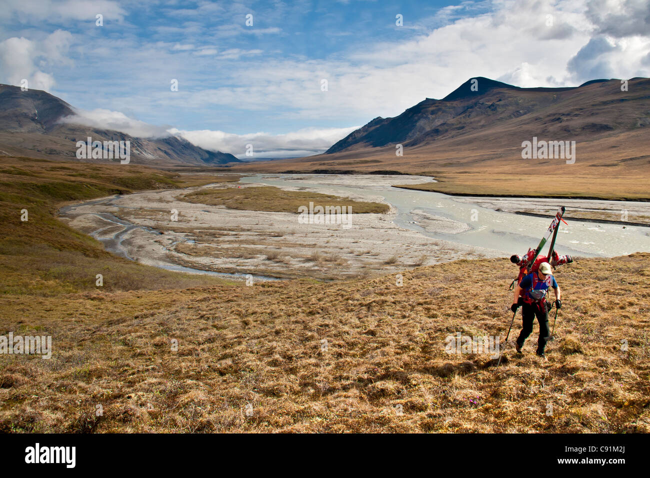 Backpacker carrying skis above the Hulahula River on the approach to ...