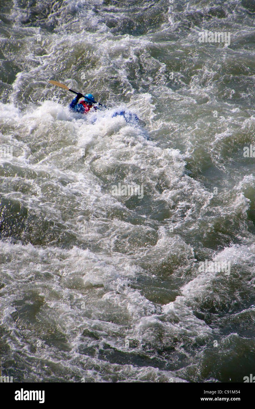 rafter paddles through whitewater on the Hulahula River rapids in a ...