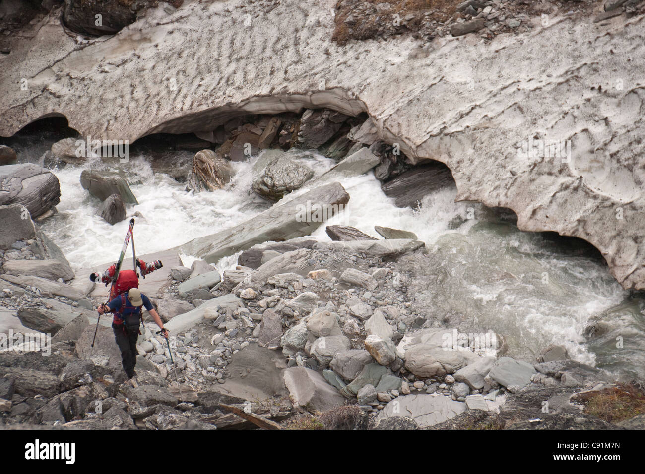 Backpacker carrying skis up Katak Creek valley on the approach to the ...