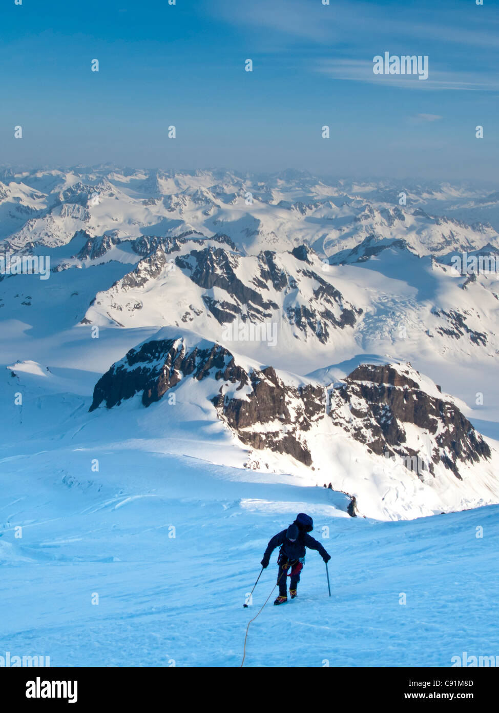 Climber leaning into high winds on northwest ridge of Mount Iliamna ...