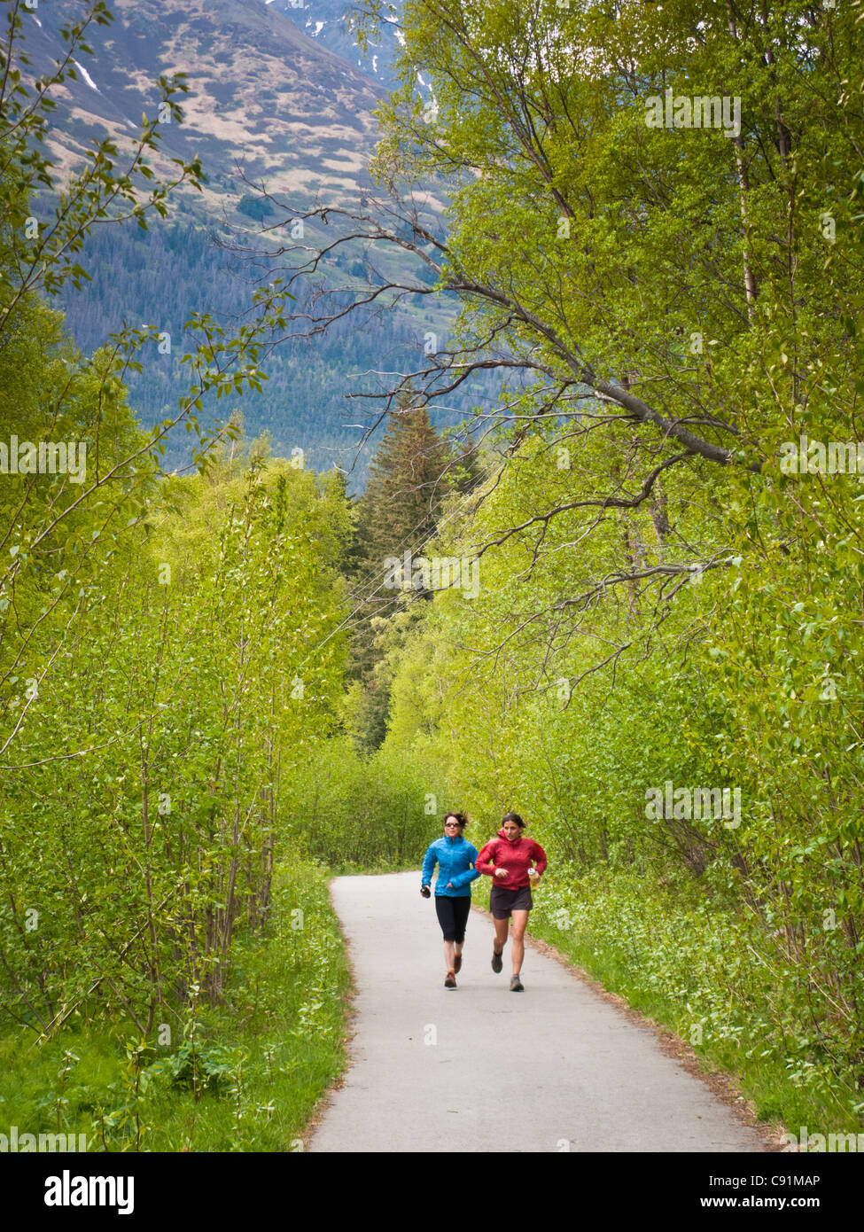 Two women trail running Bird Ridge, near Anchorage, Chugach Mountains ...