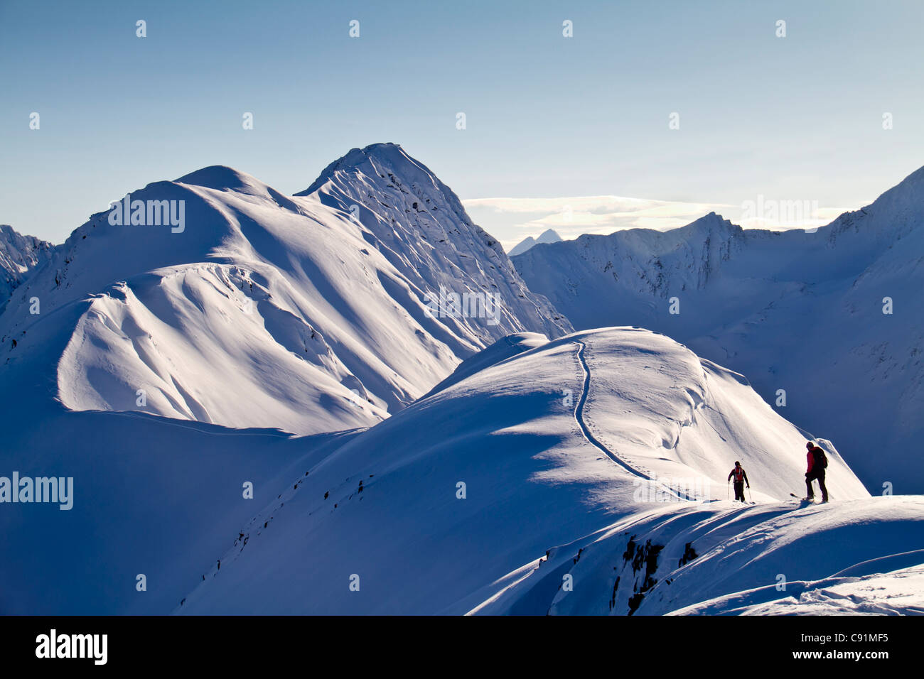 Skiers skinning the snow-covered Eddies Ridge to ski the south face to ...