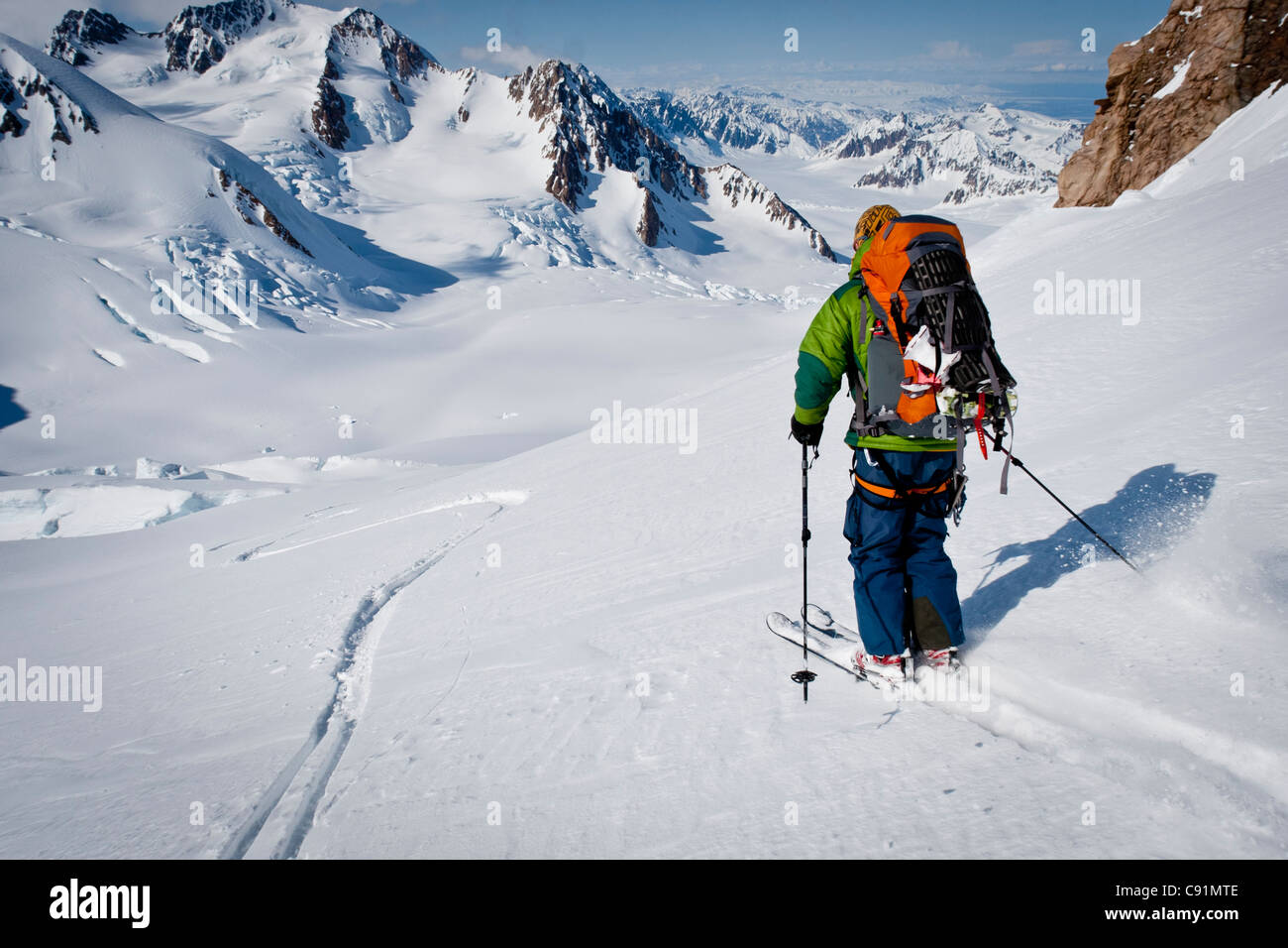 Backpacker skiing Trimble Glacier with Martin Peak(close) and Denali in ...