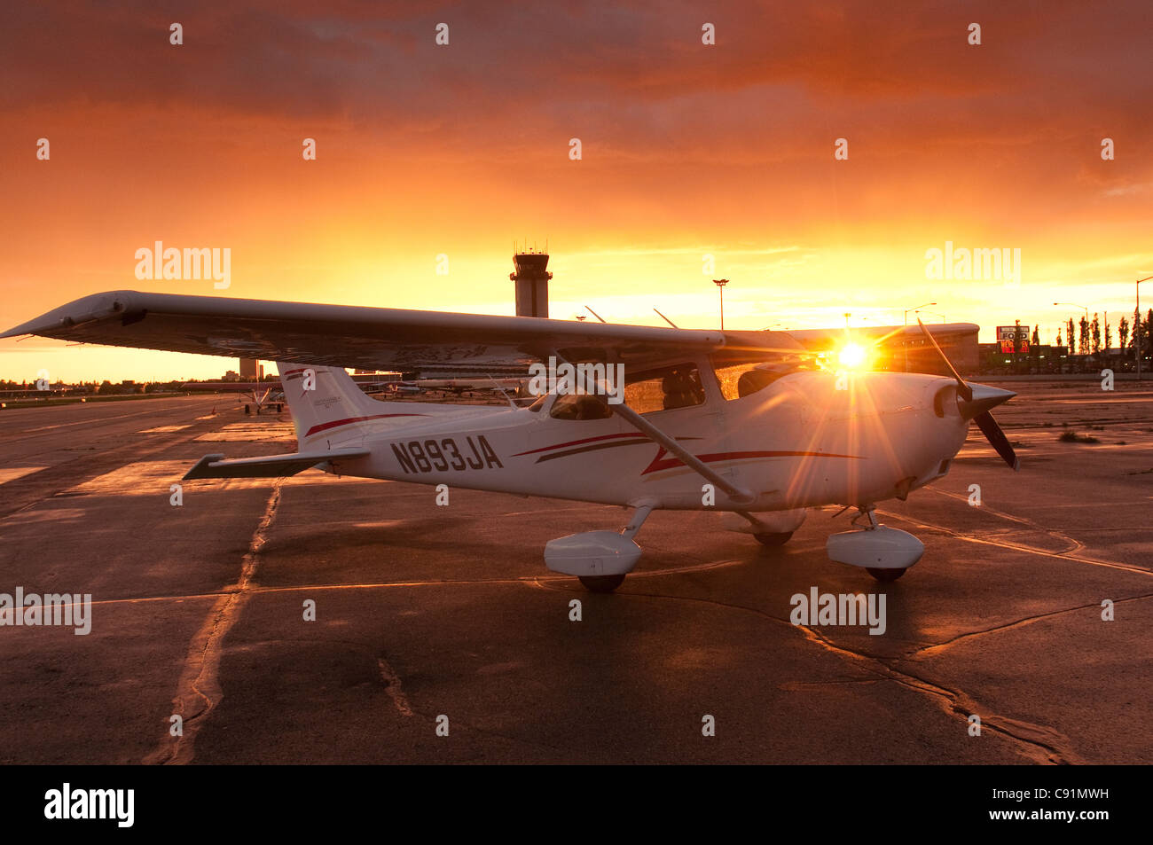 The sun sets behind a Cessna 172 at Merrill Field in Anchorage ...
