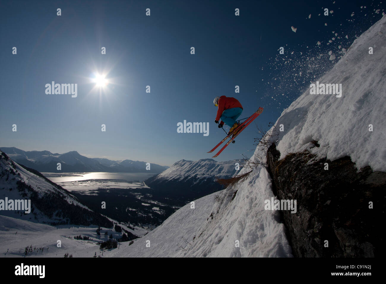 Silhouette of a downhill skier makes an extreme jump from a ledge while skiing at Alyeska Resort ...